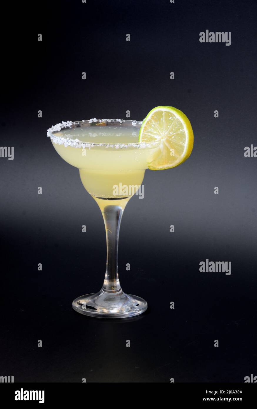 Margarita cocktail, an alcoholic drink in a tall glass with salt around ...