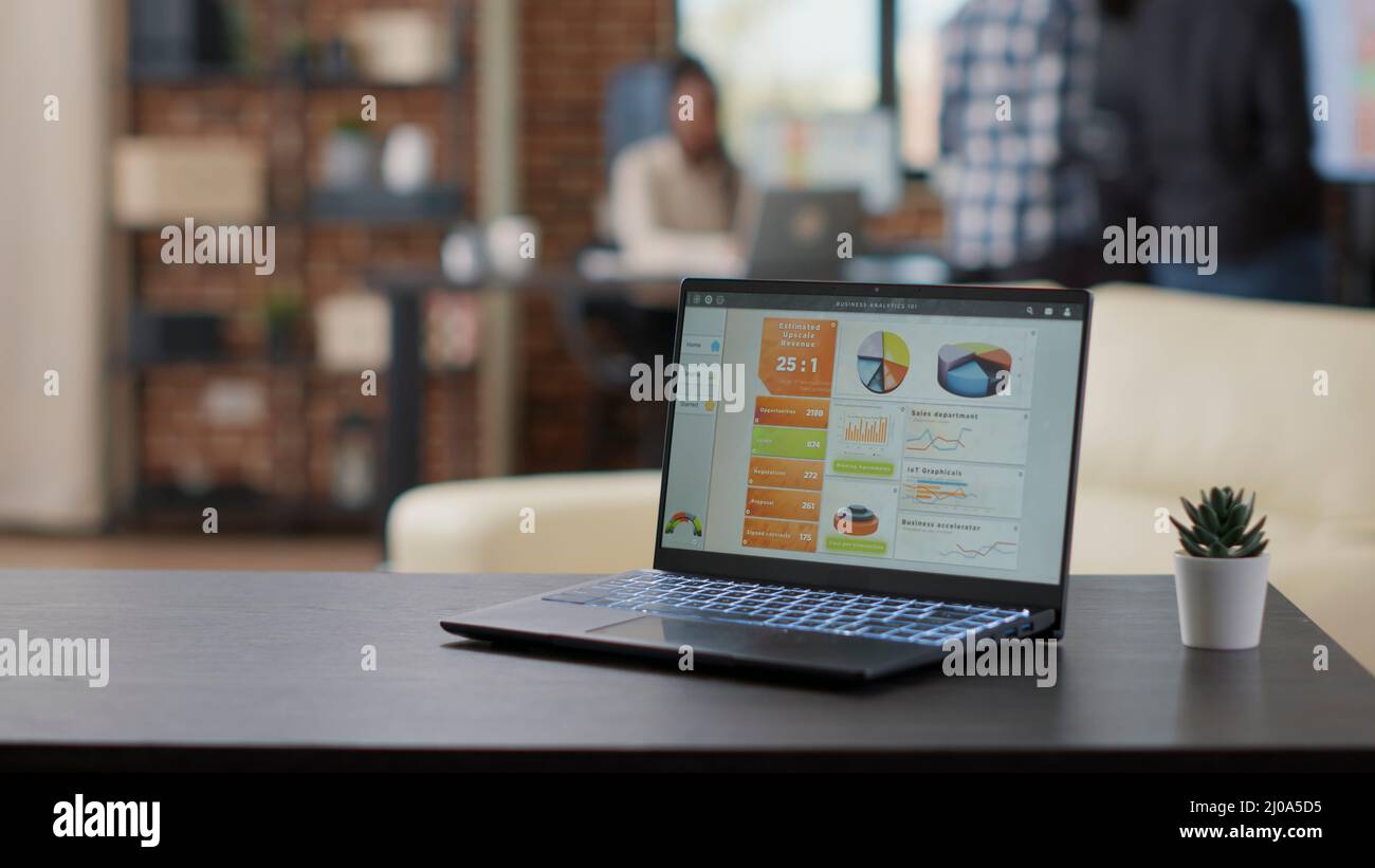 Laptop screen with financial charts and graphs on office desk, computer ...
