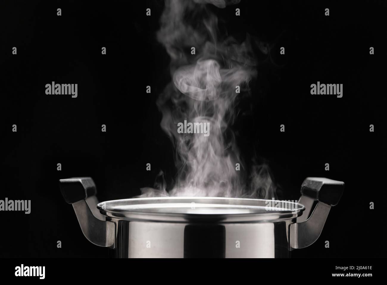 Steam over cooking pot on dark background Stock Photo - Alamy