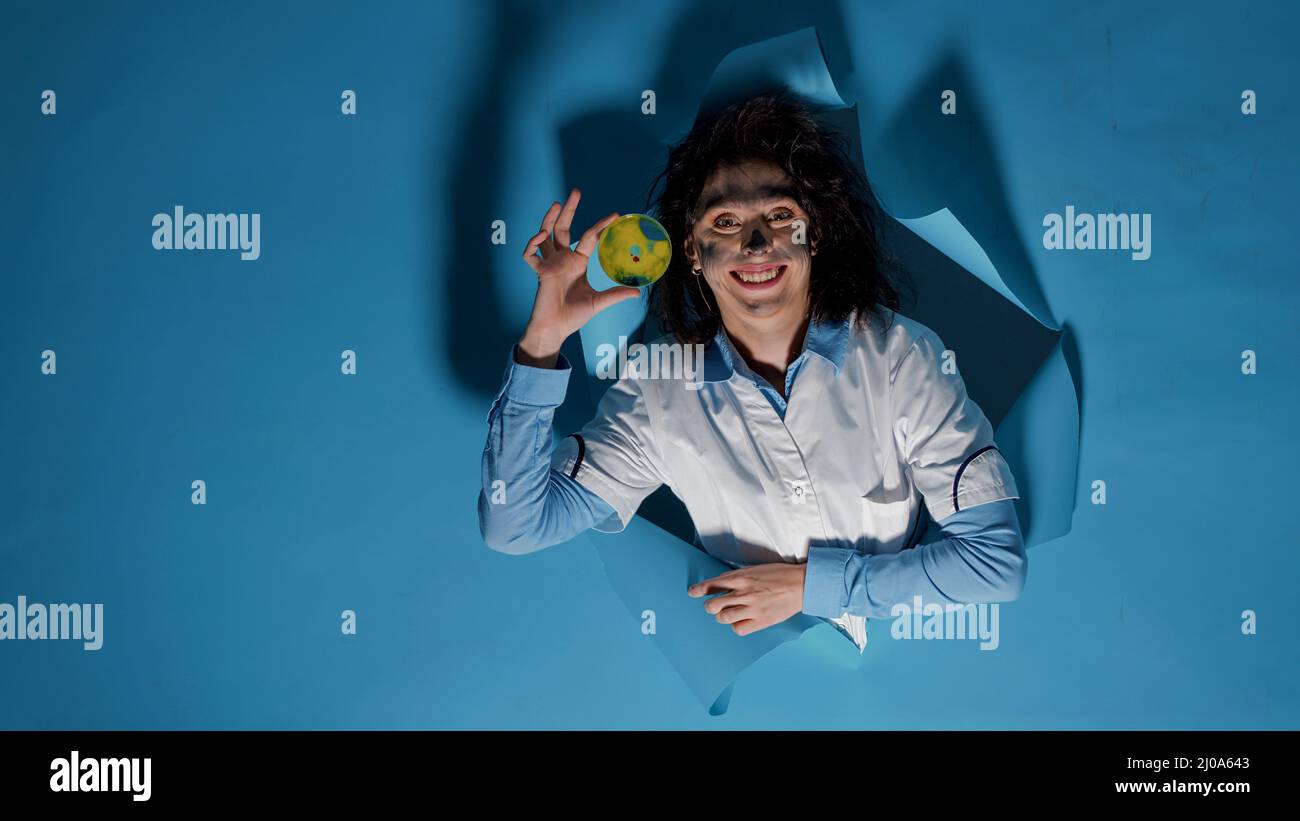 Insane funny scientist studying petri dish with liquid substance, doing ...