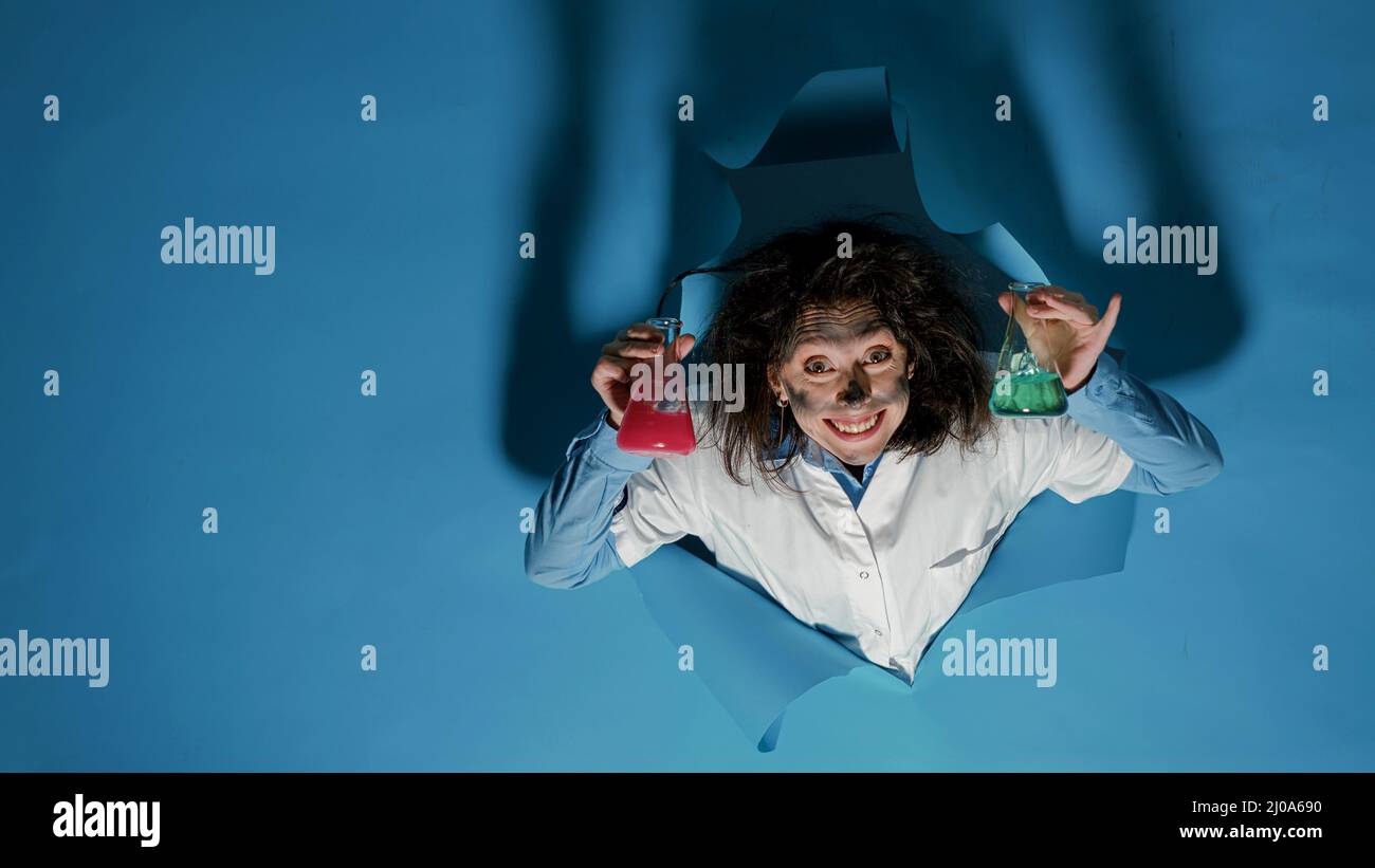 Crazy silly chemist holding laboratory beakers in studio, feeling goofy ...