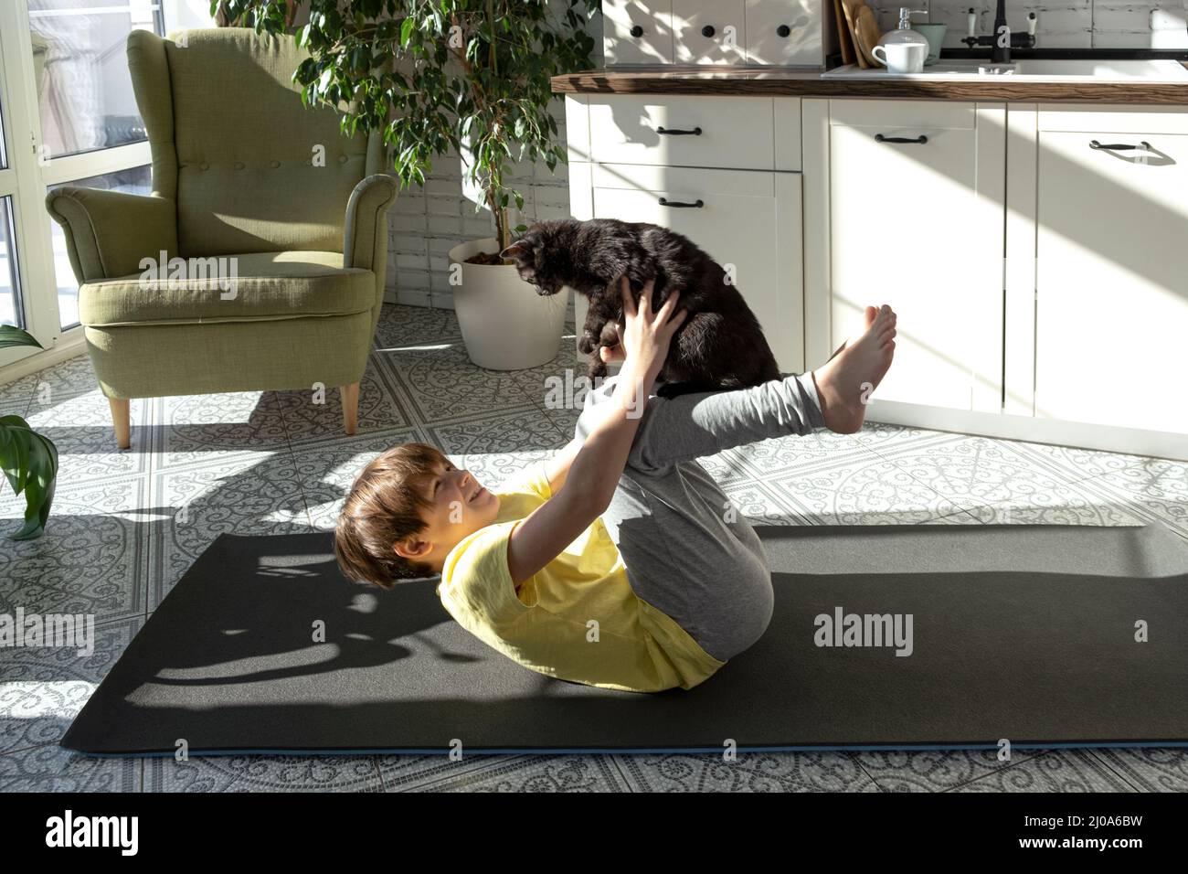 Little boy practicing yoga, stretching, fitness at home. Distant online ...