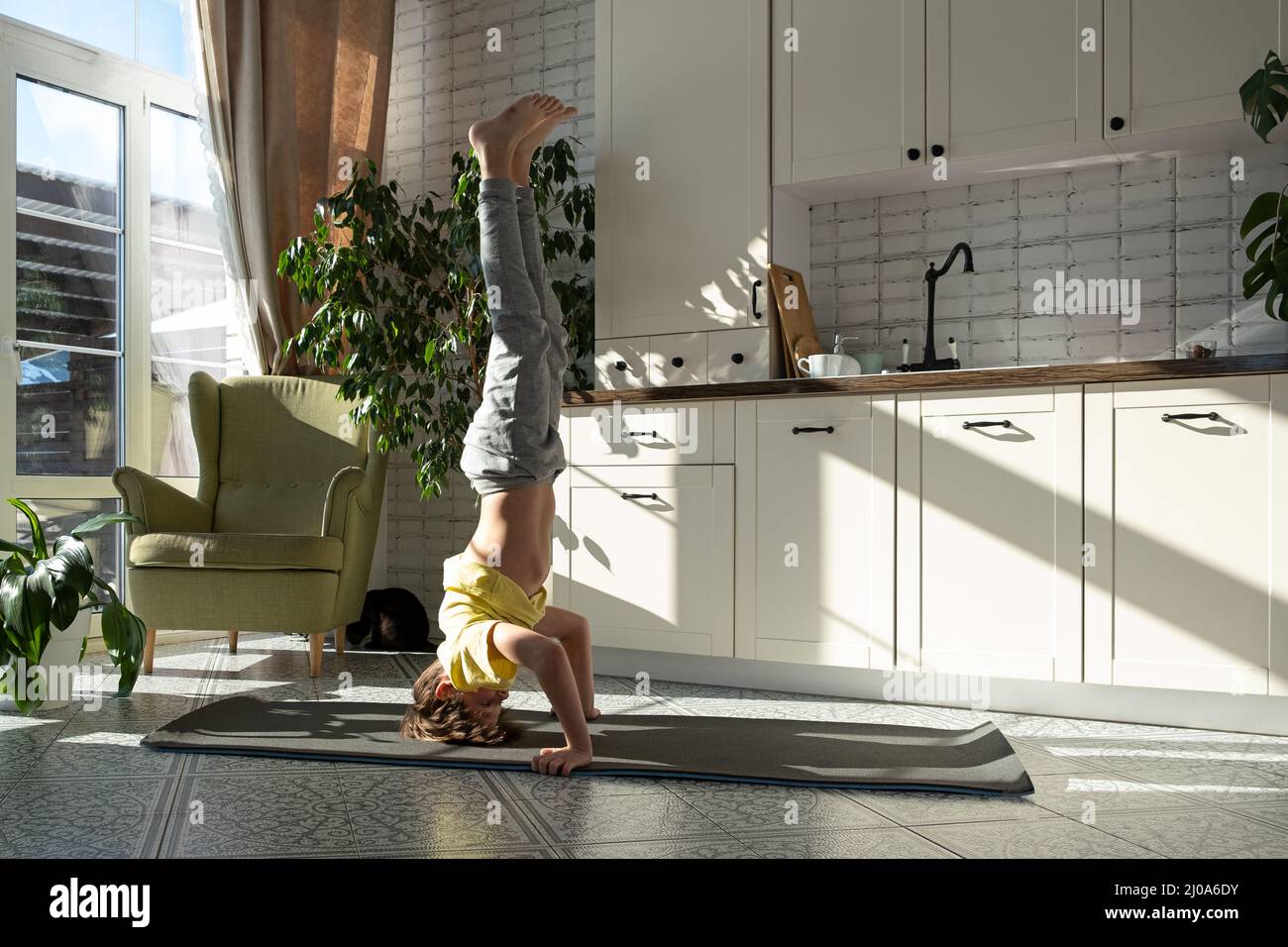 Little boy practicing yoga, stretching, fitness at home. Distant online ...