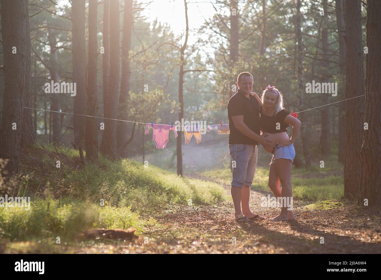 Expectant couple with baby clothes Stock Photo - Alamy