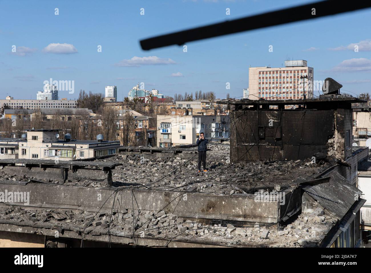 A man seen on the rooftop taking pictures of a damaged residential ...