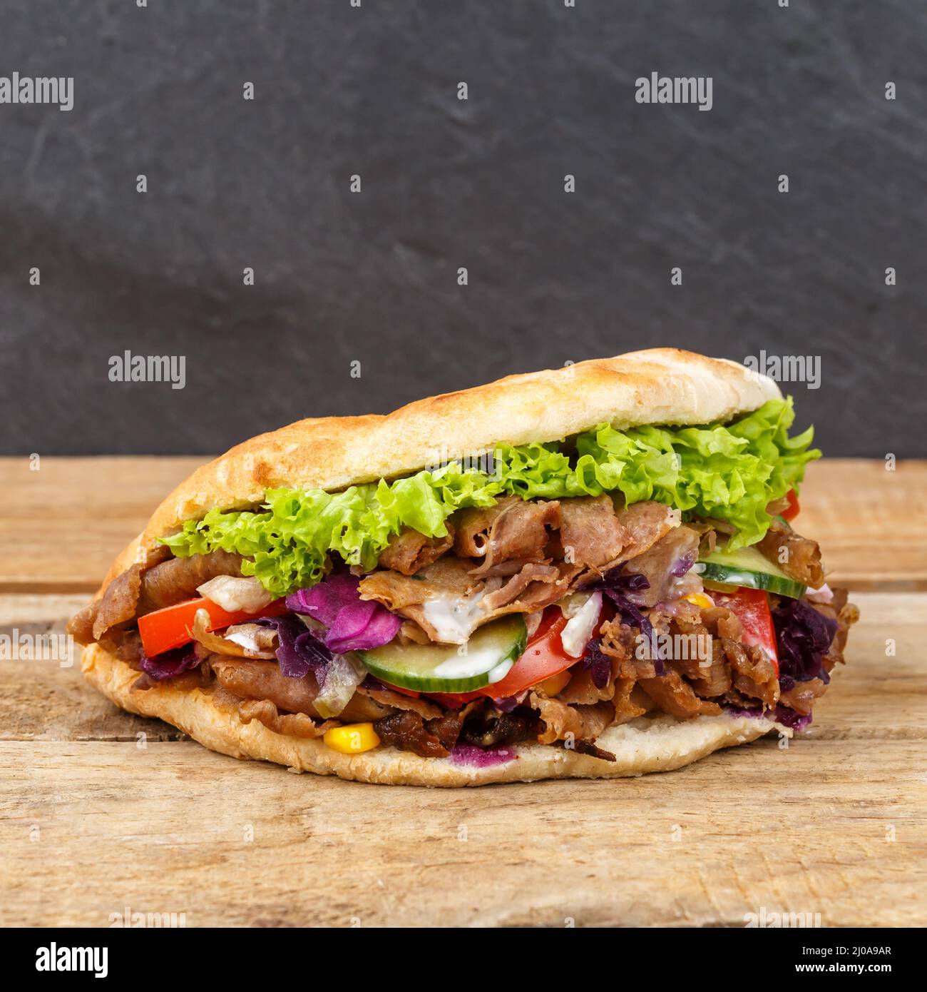 Döner Kebab Doner Kebap fast food in flatbread on a wooden board square ...