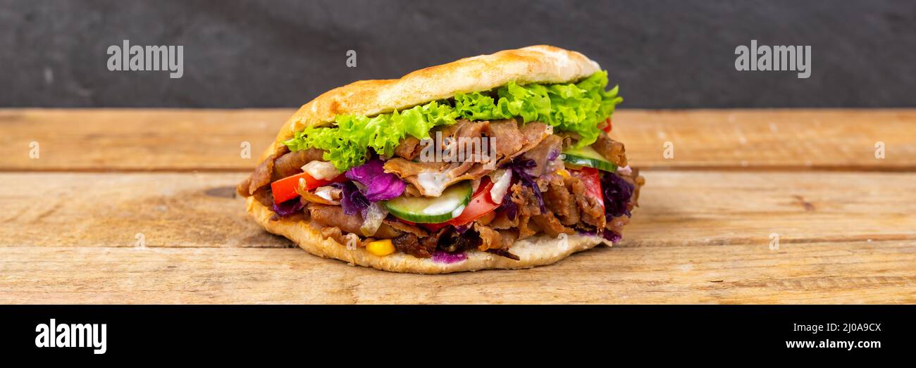 Döner Kebab Doner Kebap fast food in flatbread on a wooden board ...