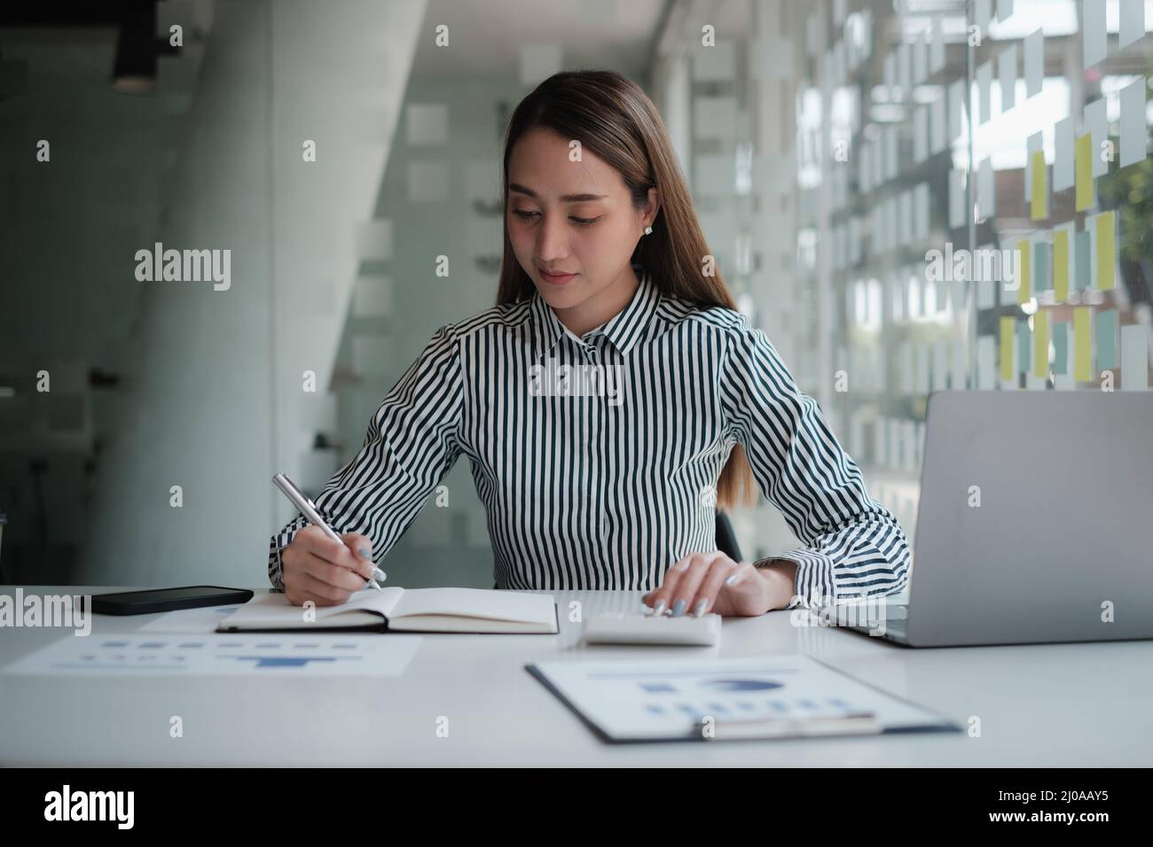 Asian Business woman working to analyze technical price graph and ...