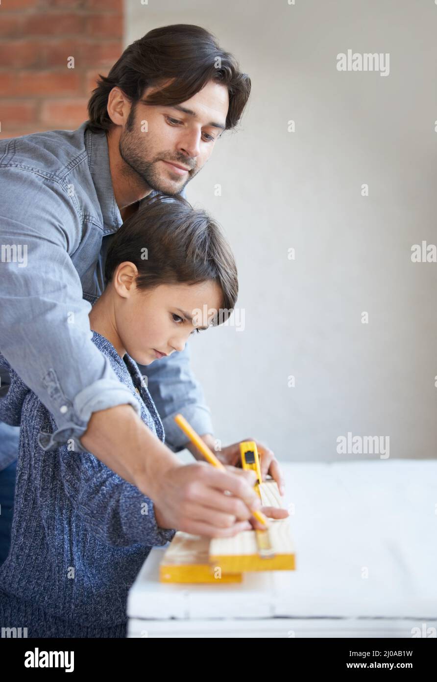 Learning everything dad has to teach. A father and son doing woodwork ...