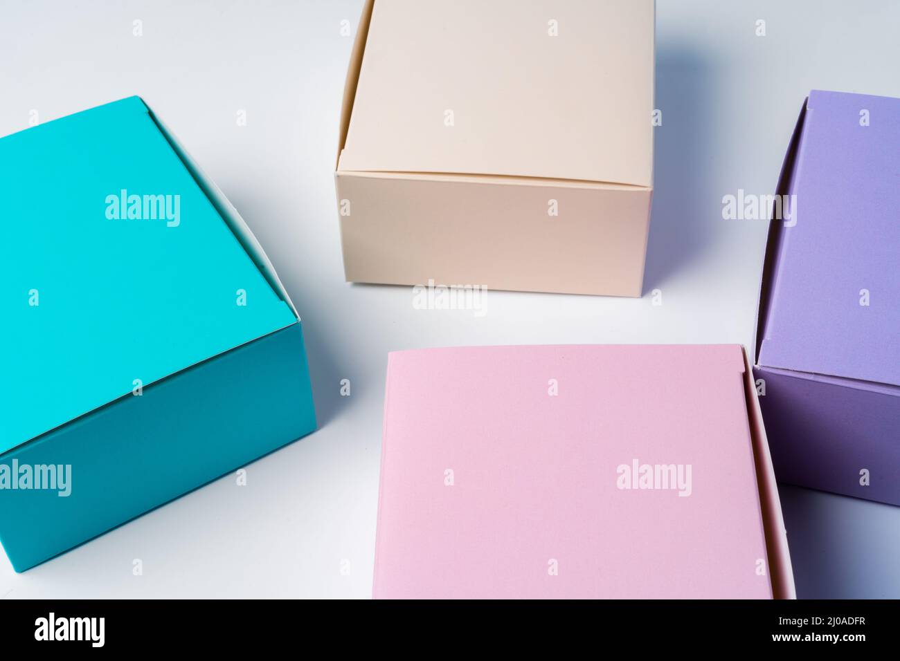 Pile of colorful cardboard boxes on white background Stock Photo - Alamy