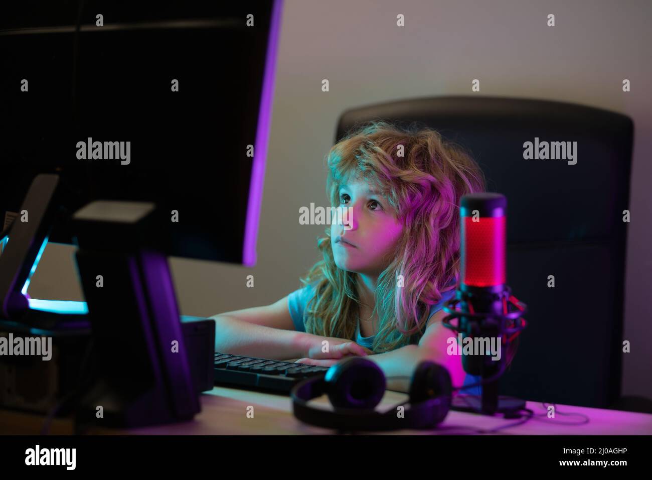 Little kid using desktop pc by night, child boy illuminated by the blue ...