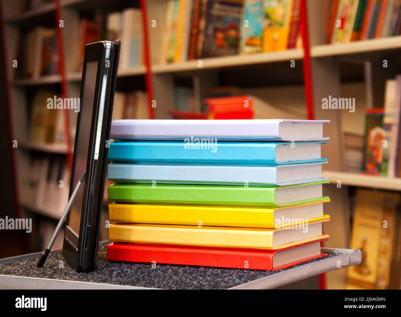 Stack of colorful books with electronic book reader Stock Photo - Alamy