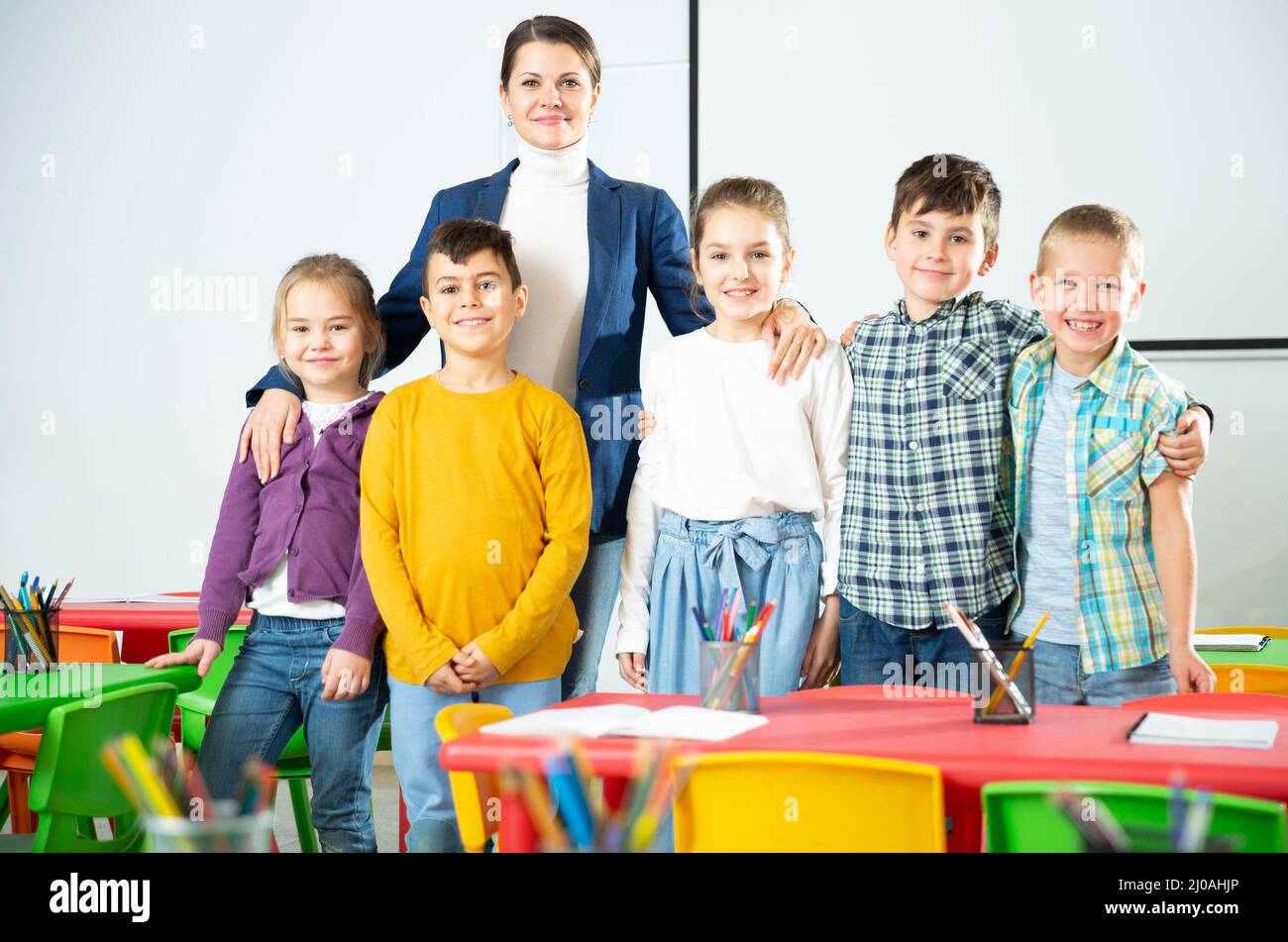 Teacher and happy children in classroom Stock Photo - Alamy