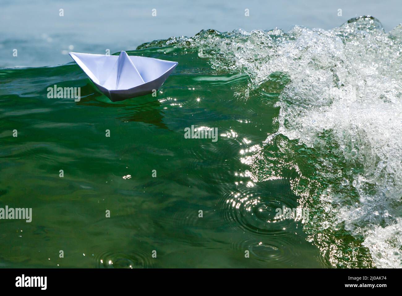 Paper boat struggling with a huge foamy waves Stock Photo - Alamy