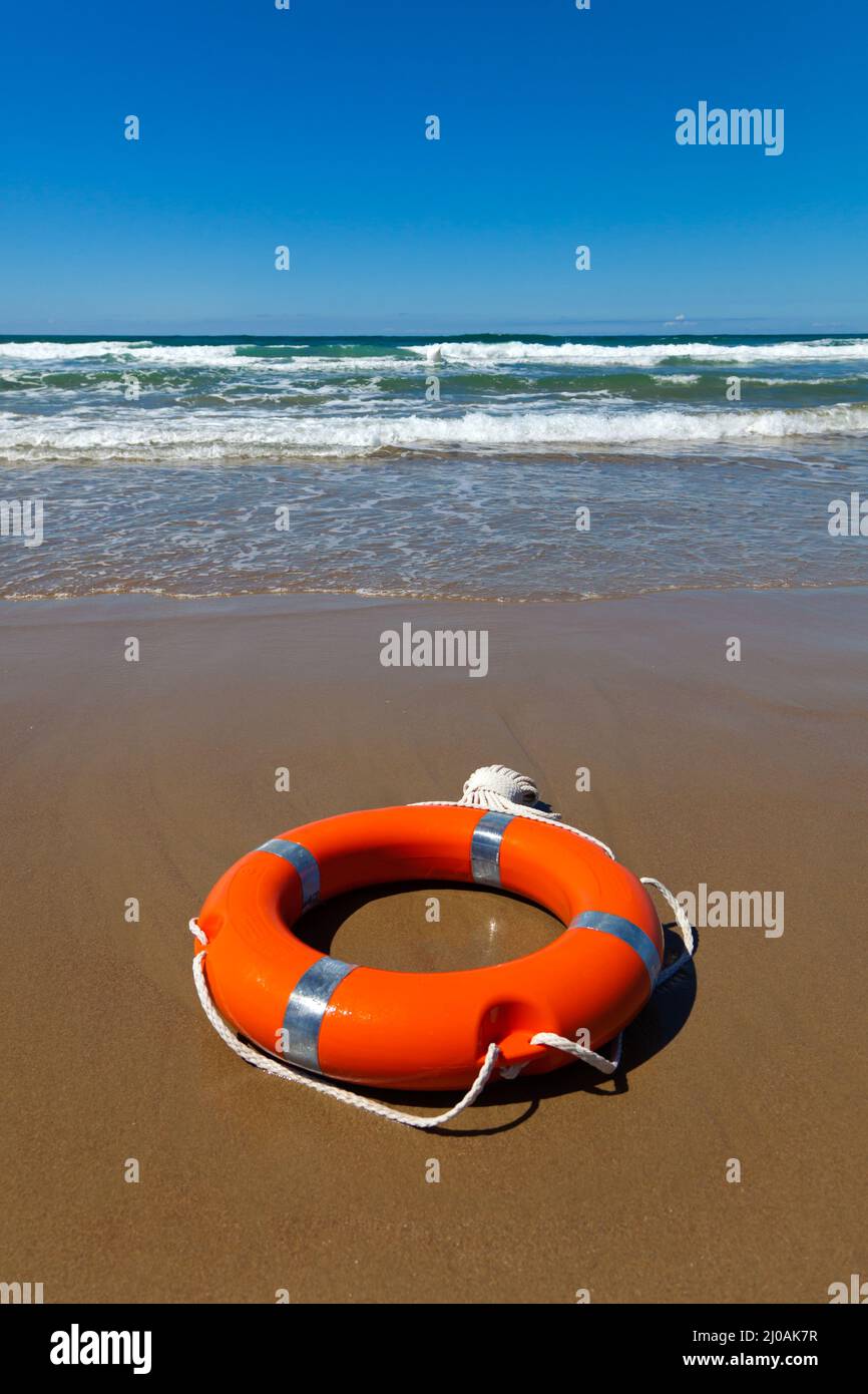 Red lifebuoy lying on the sand on the beach Stock Photo - Alamy