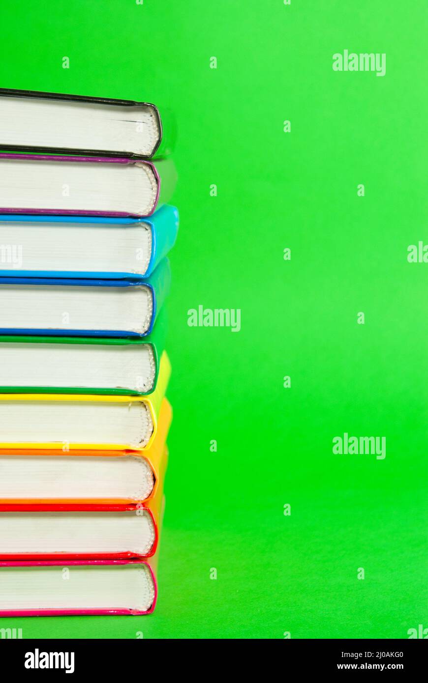 Stack of books' spines over green background Stock Photo - Alamy