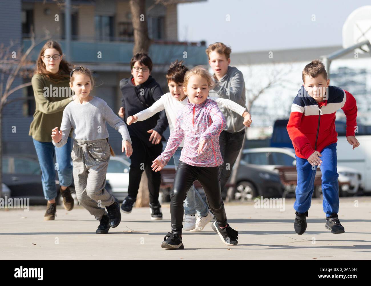 Group of joyful children running down the city street Stock Photo - Alamy