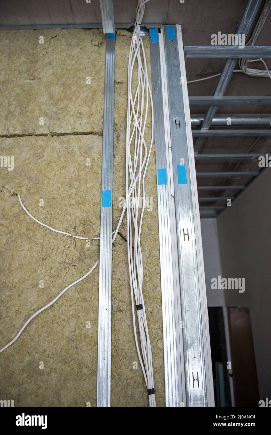 Vertical shot of metal parring and electrical wires on the wall of a ...