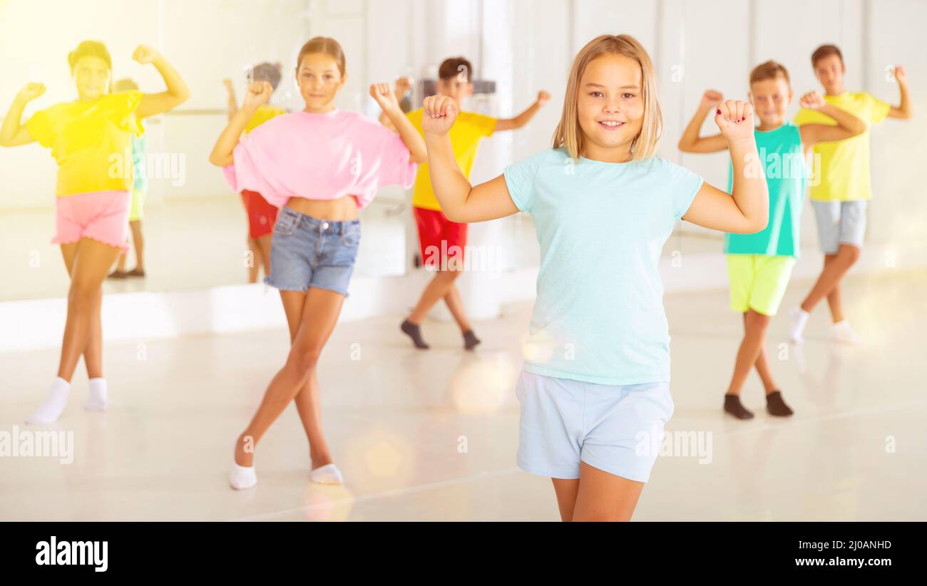 Smiling little girl training vigorous dance with group of tweens Stock ...