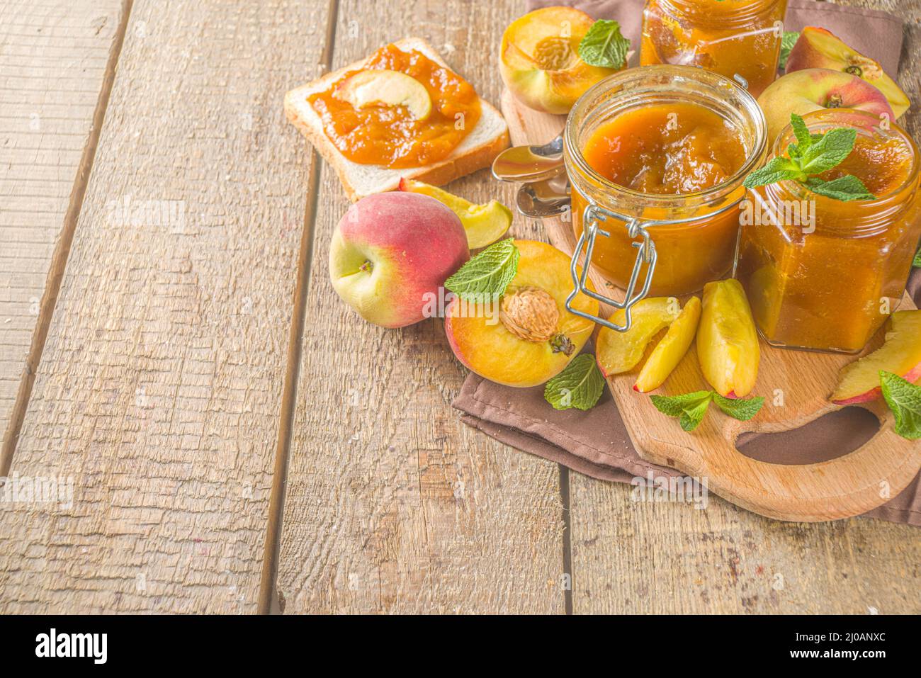 Homemade peach jam in different jars, with fresh organic peaches on ...