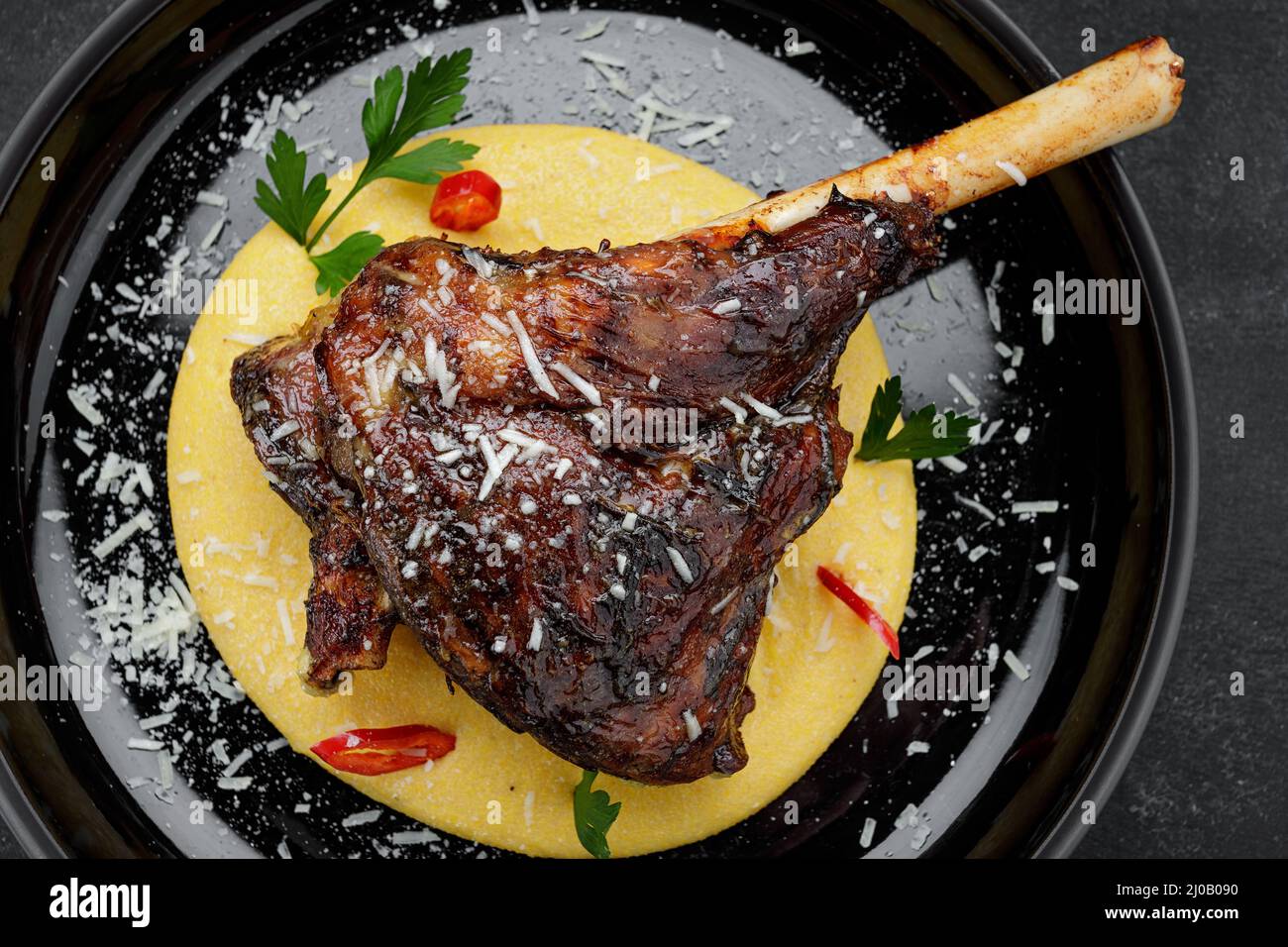 Fried leg of lamb with garnish and pepper Stock Photo - Alamy
