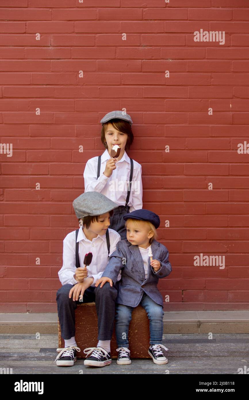 Cute child, boy in vintage cloths, eating lollipop ice cream, sitting ...