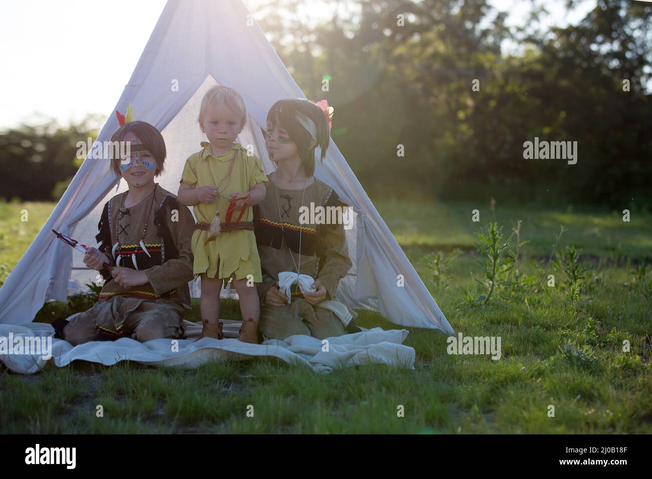 Cute portrait of native american boys with costumes, playing outdoor in ...