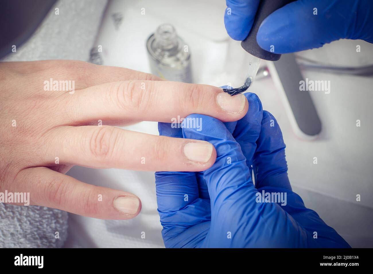 Finger nail treatment, grinding and polishing in beauty salon. Manicure ...