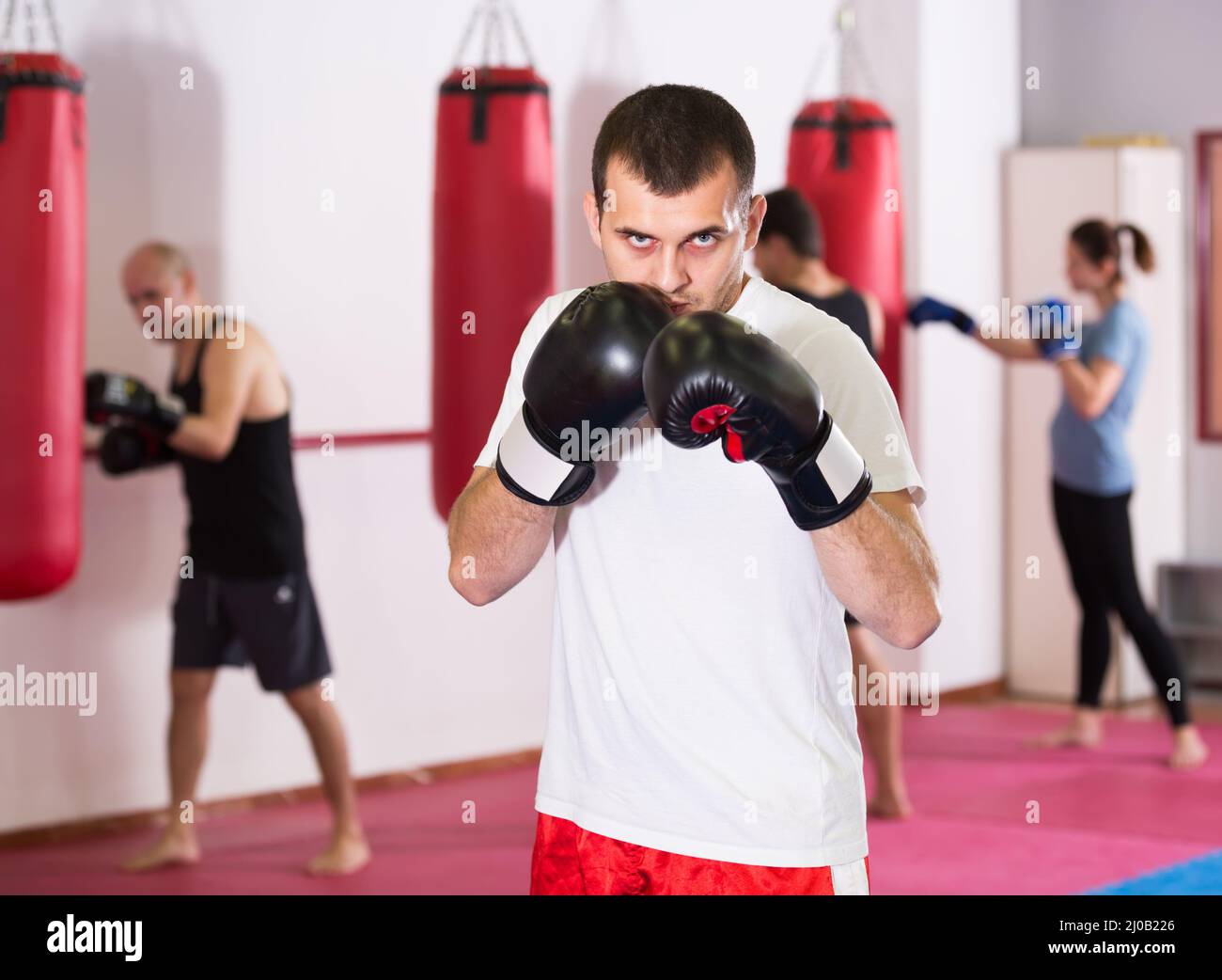 serious sportsman in the boxing hall practicing boxing punches Stock ...