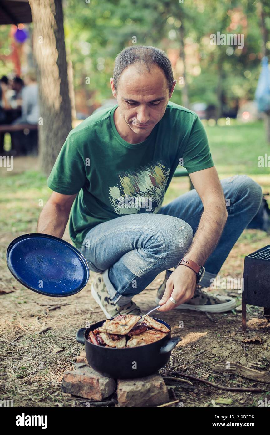 Man puts meat in pot hi-res stock photography and images - Alamy