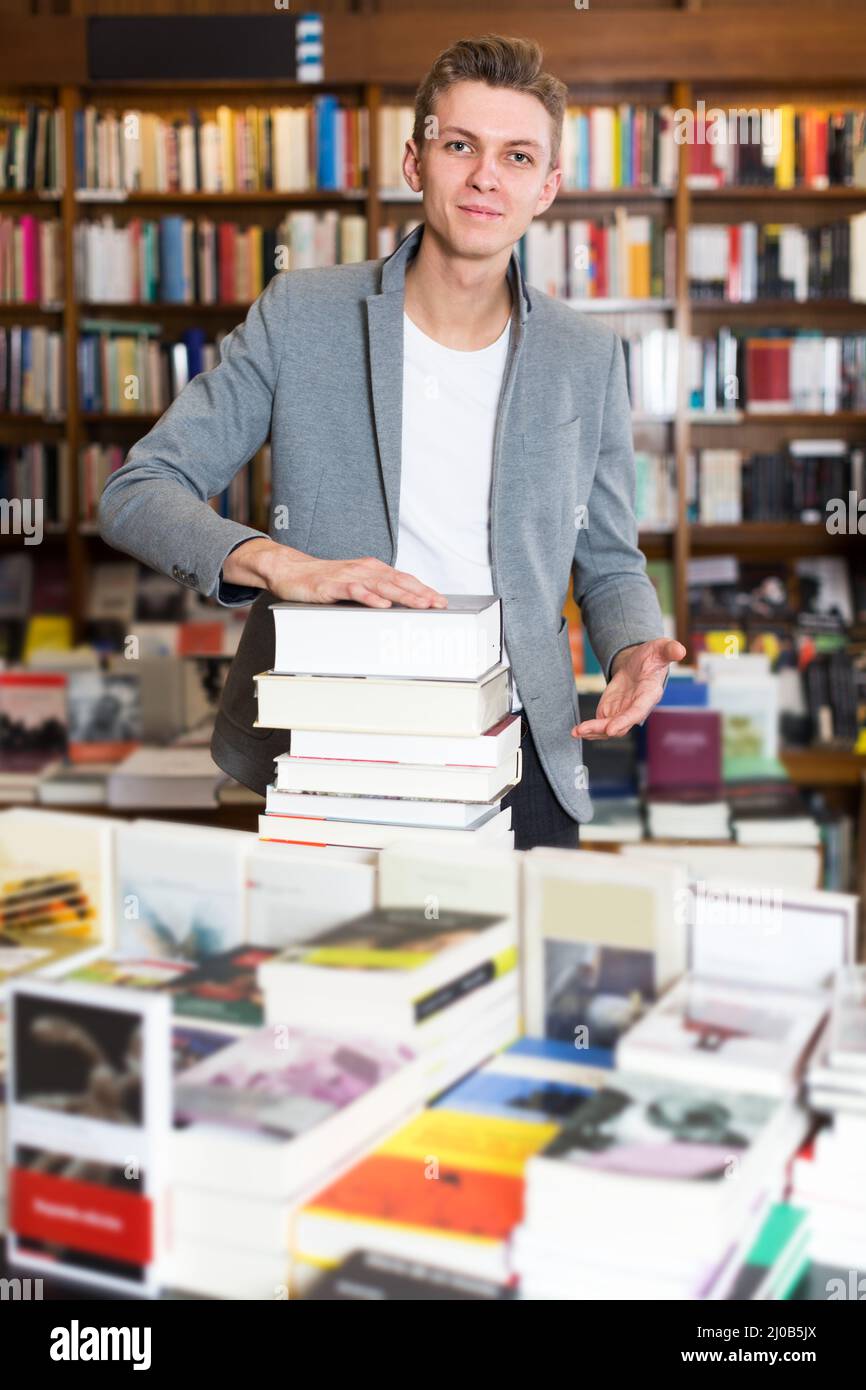 Guy holding books in store Stock Photo - Alamy