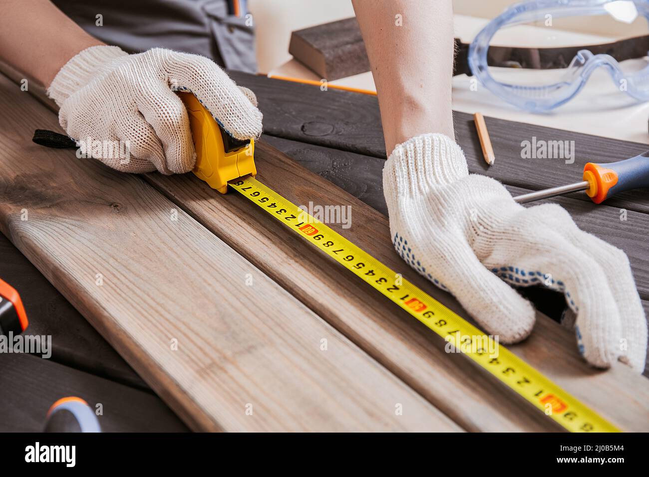 Carpenter is measuring length of wood planks or timbers by measuring ...