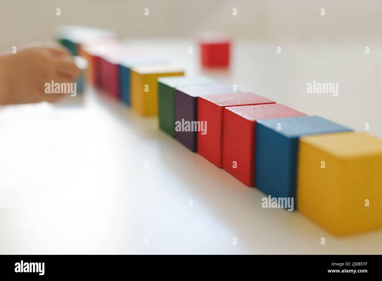 child playing and building with colorful wooden toy bricks on white ...