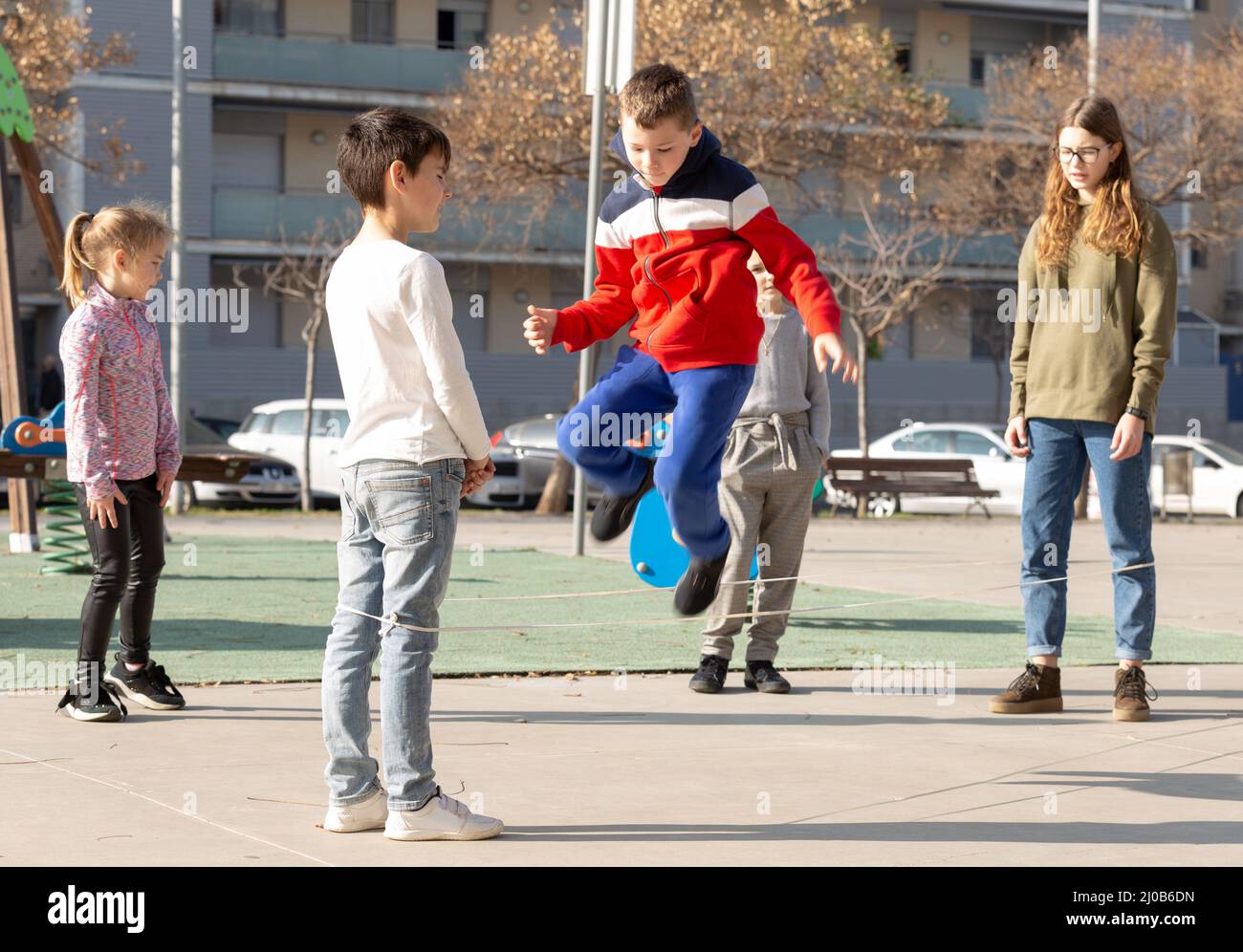 Children skipping on elastic jump rope Stock Photo - Alamy