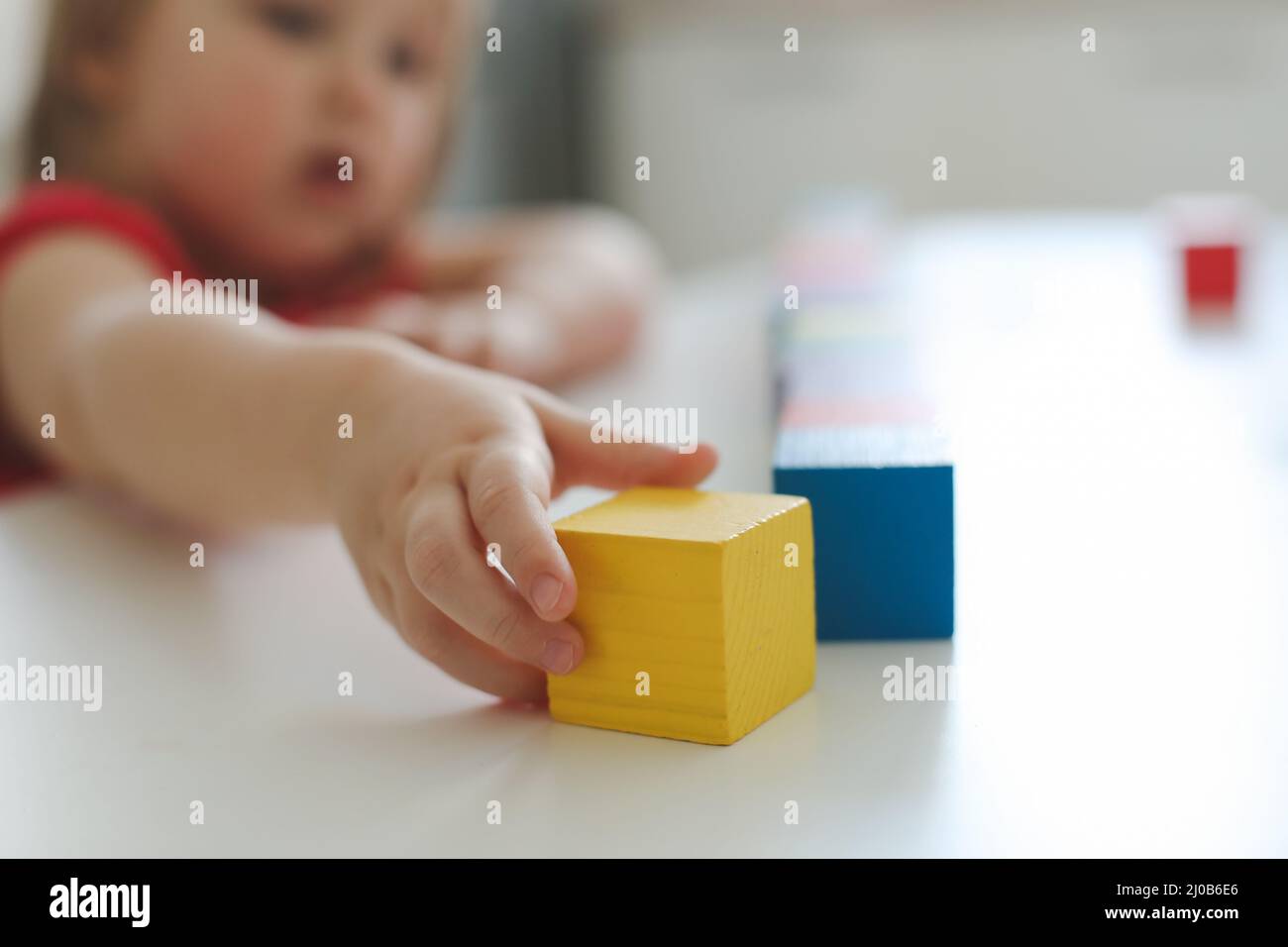 child playing and building with colorful wooden toy bricks on white ...