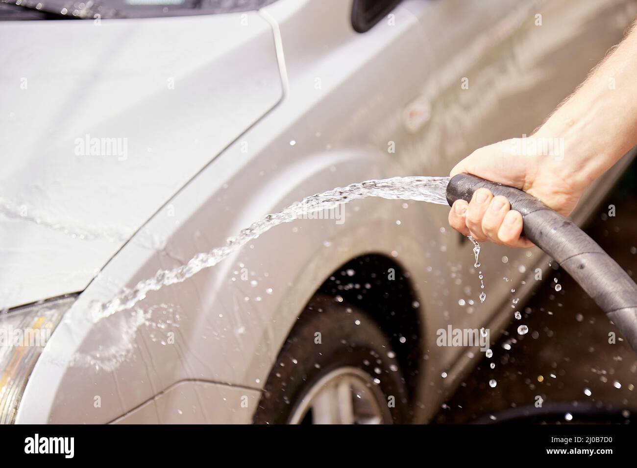 Washing the auto with water under the hoses outside. Home routines ...