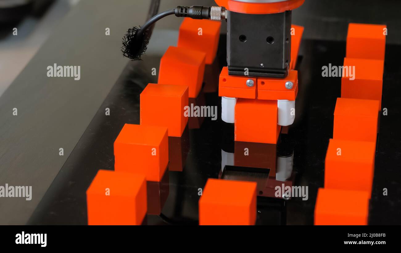 Pick and place robotic arm manipulator moving red toy blocks at robot exhibition Stock Photo - Alamy