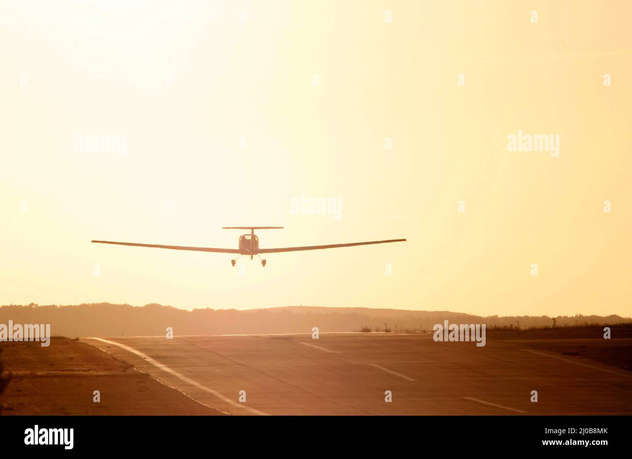Light aircraft taking off into sunset Stock Photo - Alamy