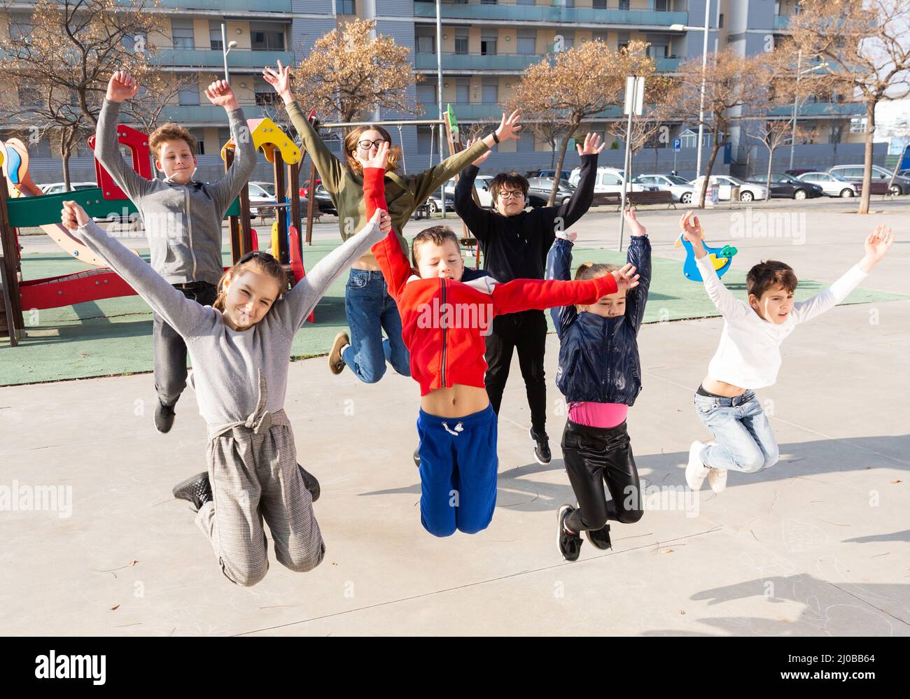 Happy children jumping on playground Stock Photo - Alamy