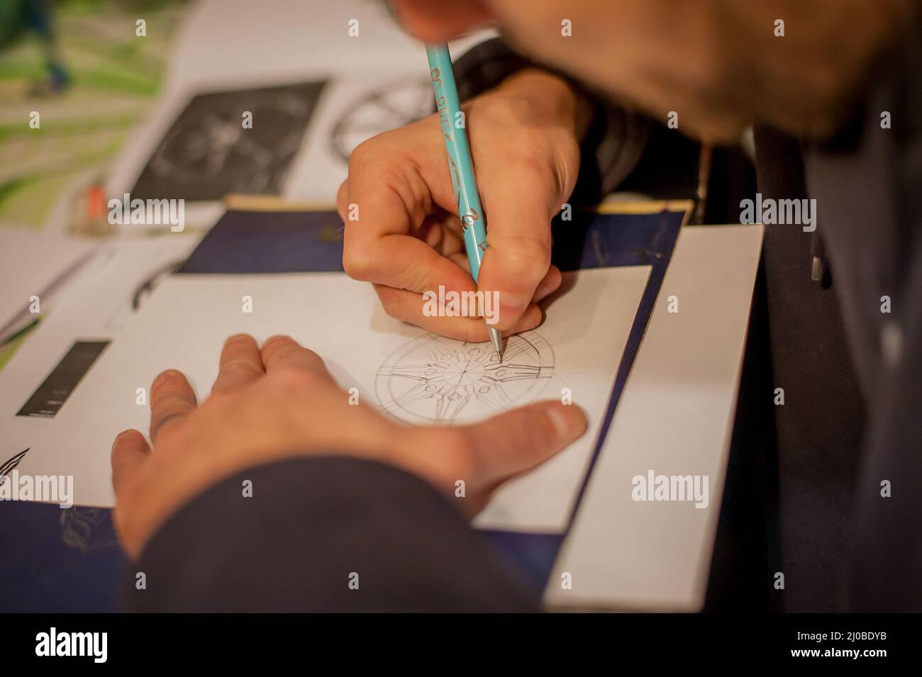 Tattoo artist drawing tattoo in his studio Stock Photo - Alamy
