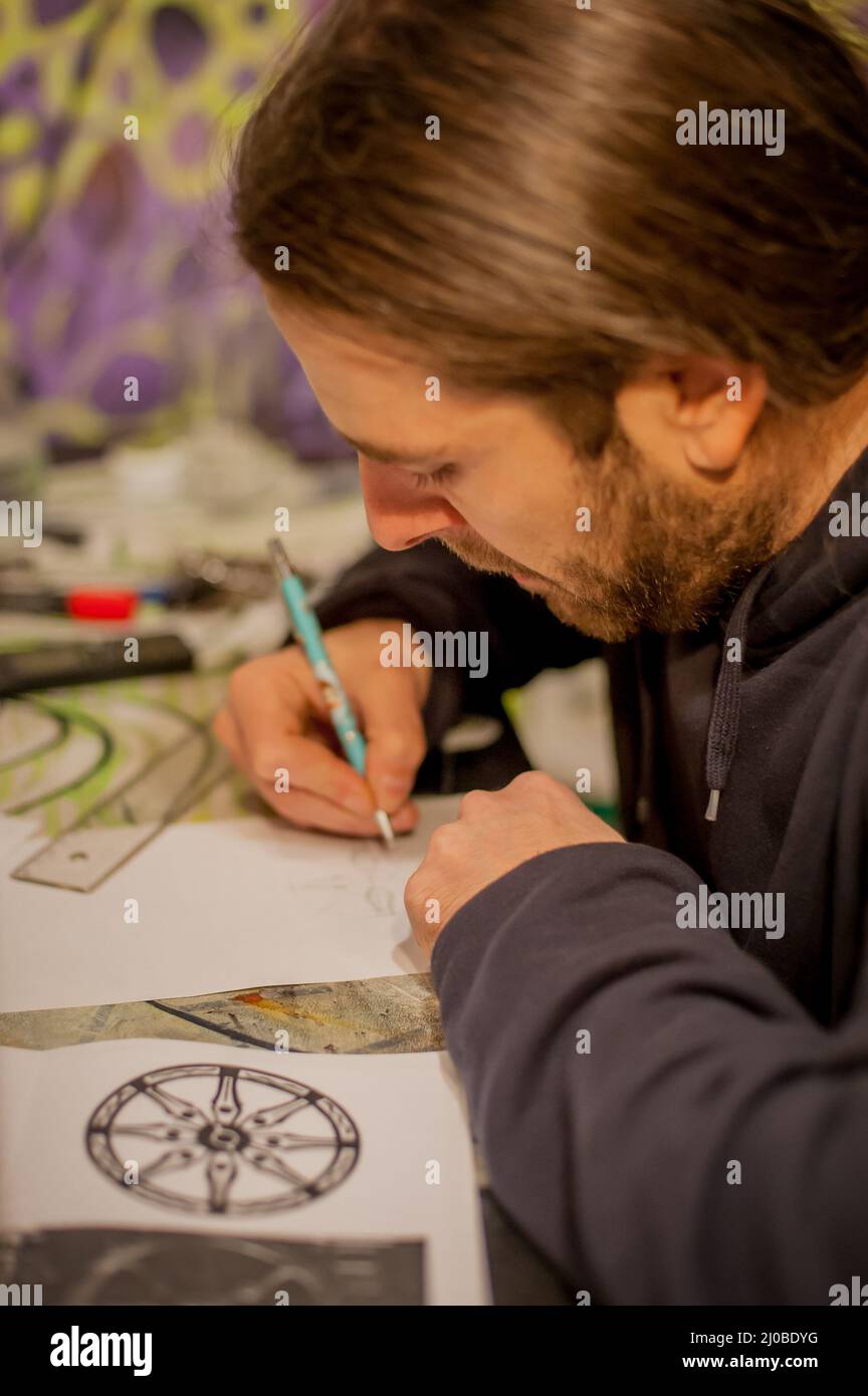 Tattoo artist drawing tattoo in his studio Stock Photo - Alamy