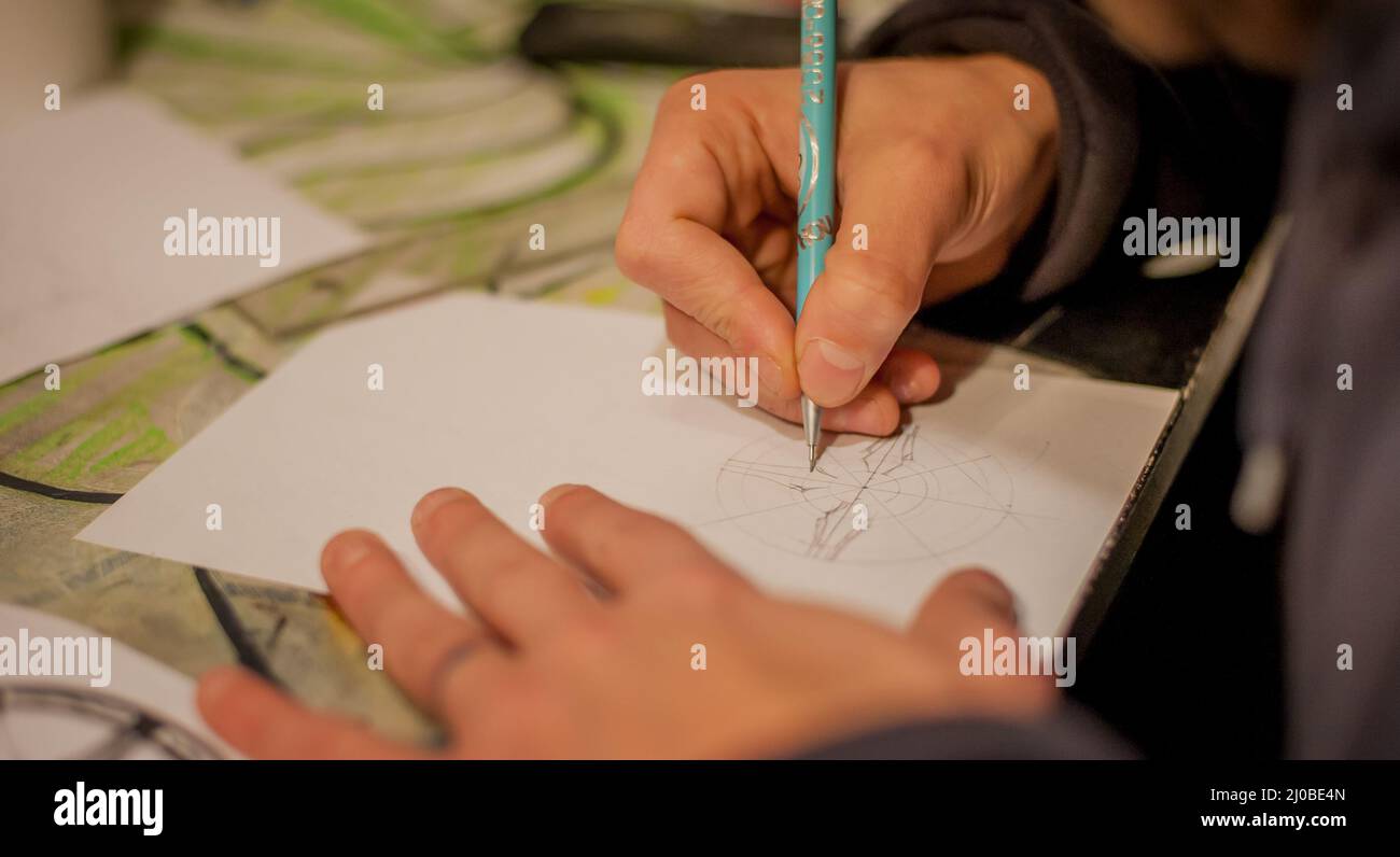 Tattoo artist drawing tattoo in his studio Stock Photo - Alamy