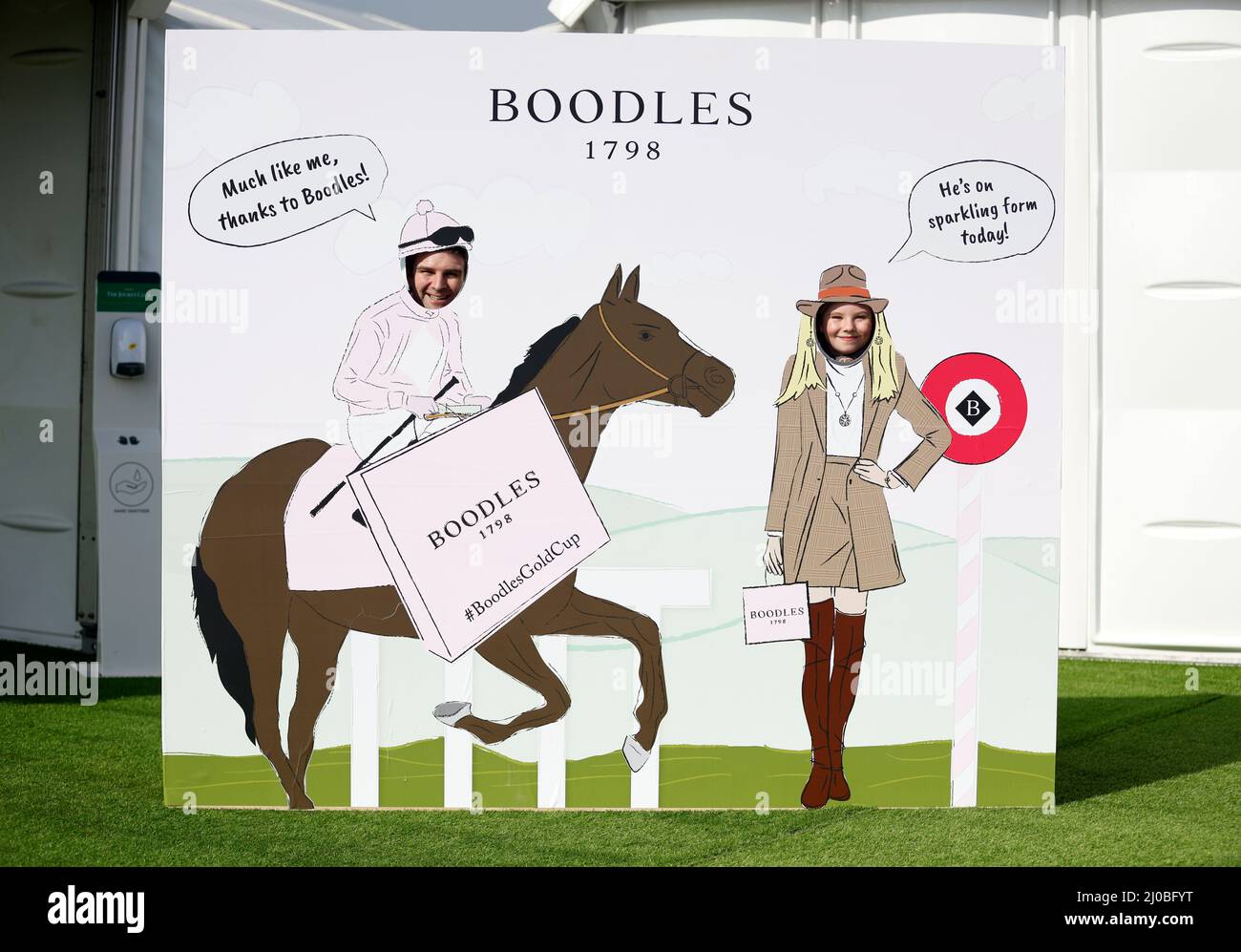 Spectators put their heads in a Boodles face in the hole board during ...