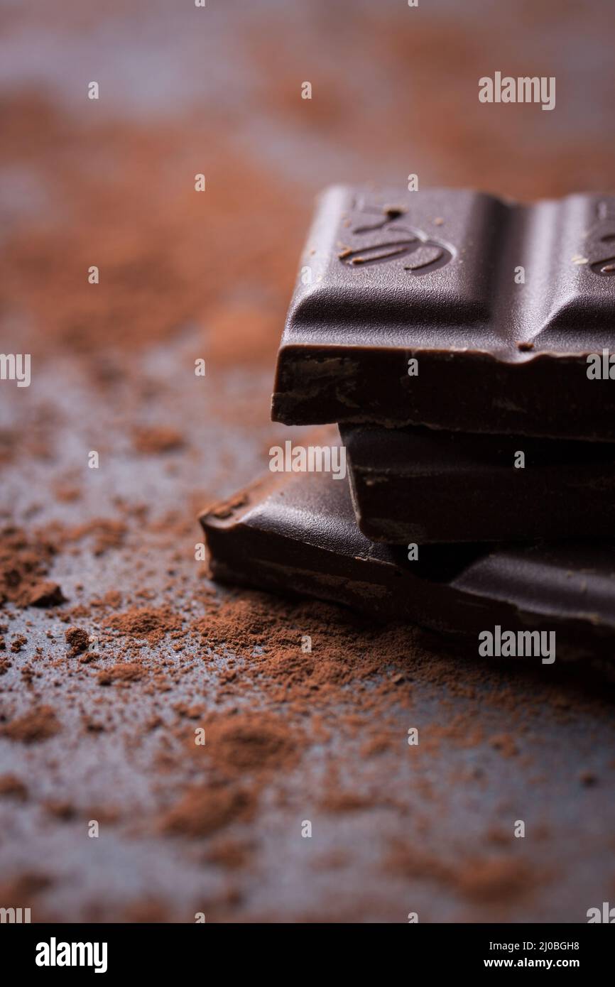 Dark chocolate stack with cocoa powder on a stone background Stock ...