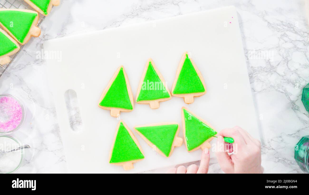 Flat lay. Stp by step. Icing Christmas tree-shaped sugar cookies with ...