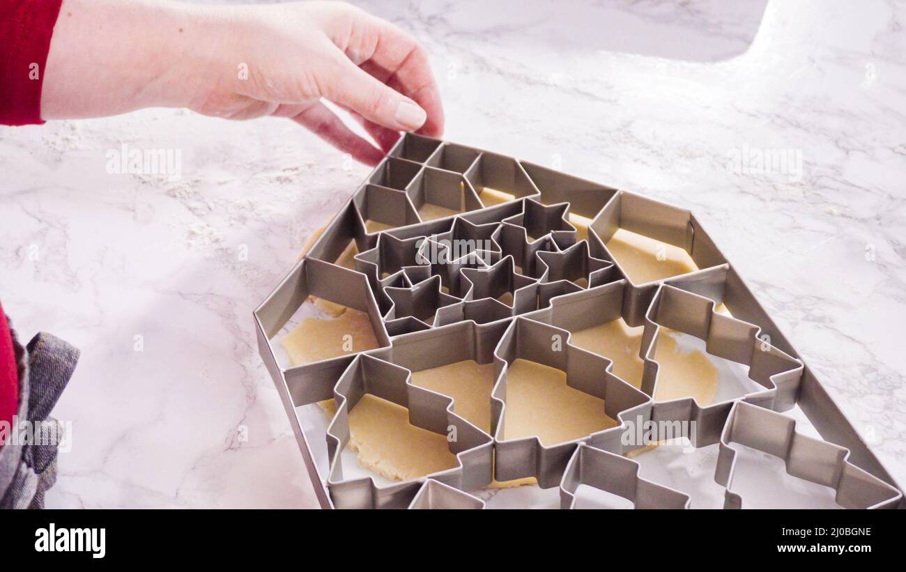 Cutting out sugar cookies with giant Christmas cookie cutter Stock ...