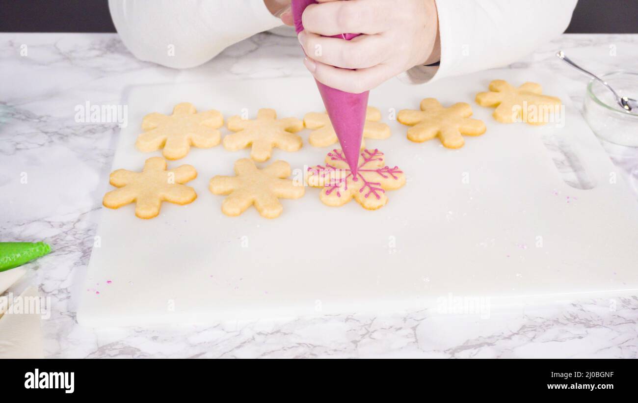 Stp by step. Icing snowflake shaped sugar cookies with pink royal icing ...