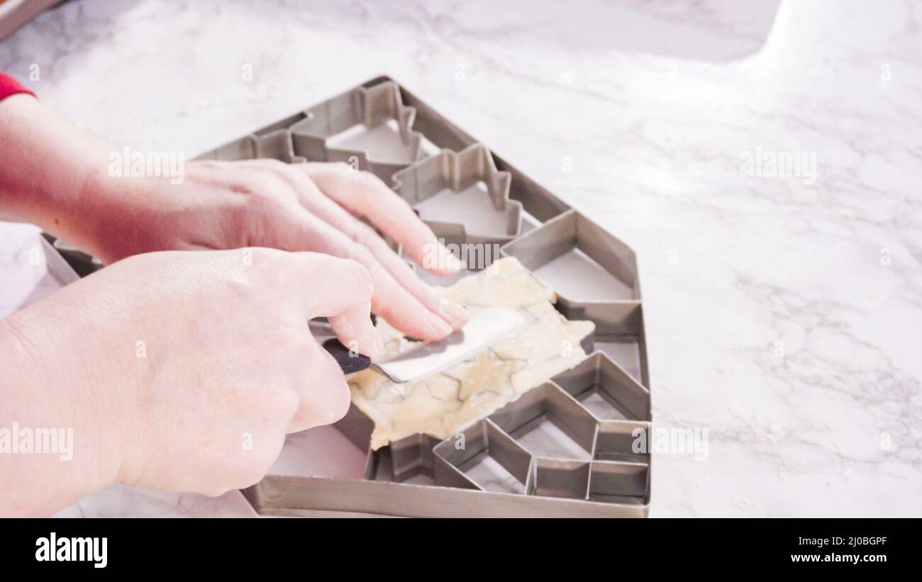 Cutting out sugar cookies with giant Christmas cookie cutter Stock ...