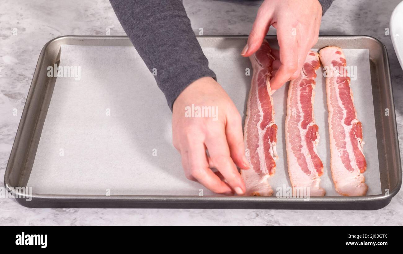 Step by step. Uncooked bacon strips on a baking sheet with white ...