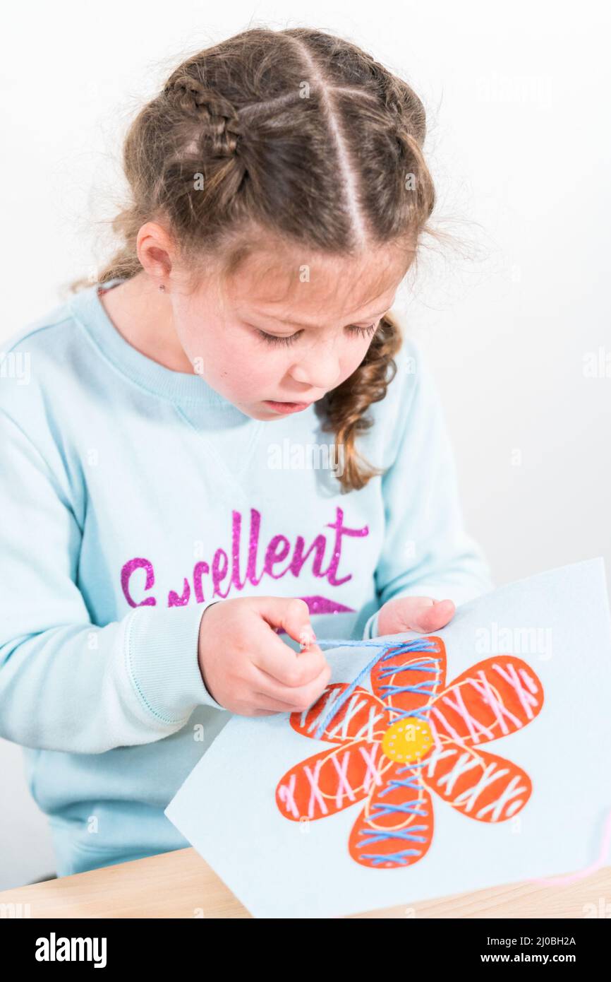 Little girl learning how to sew with sewing craft kit for kids Stock ...